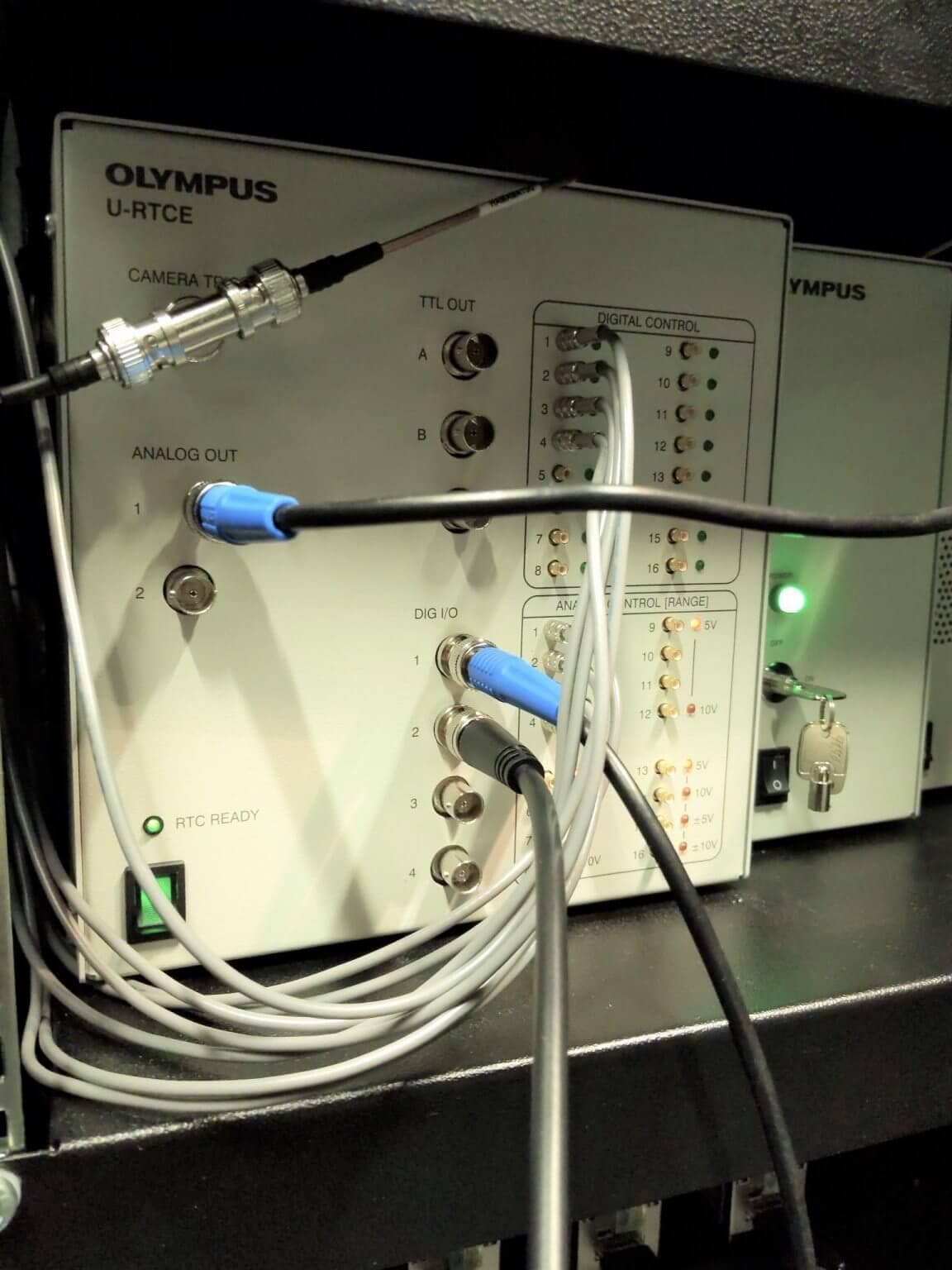 How do you synchronize a microscope with a microfluidic perfusion system?